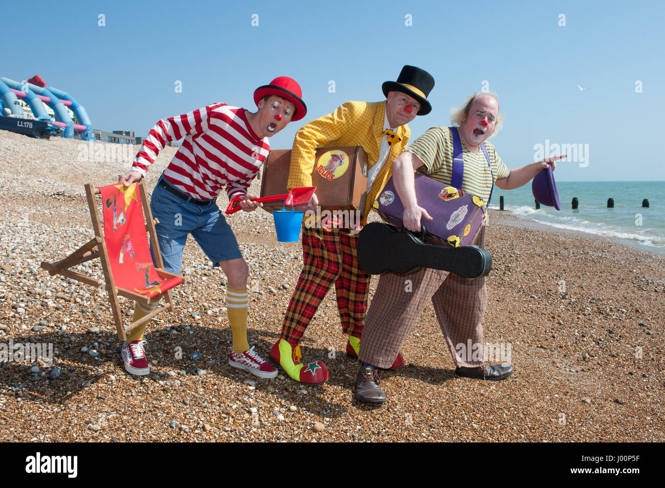Three clowns on the beach having fun on a sunny day during the ...