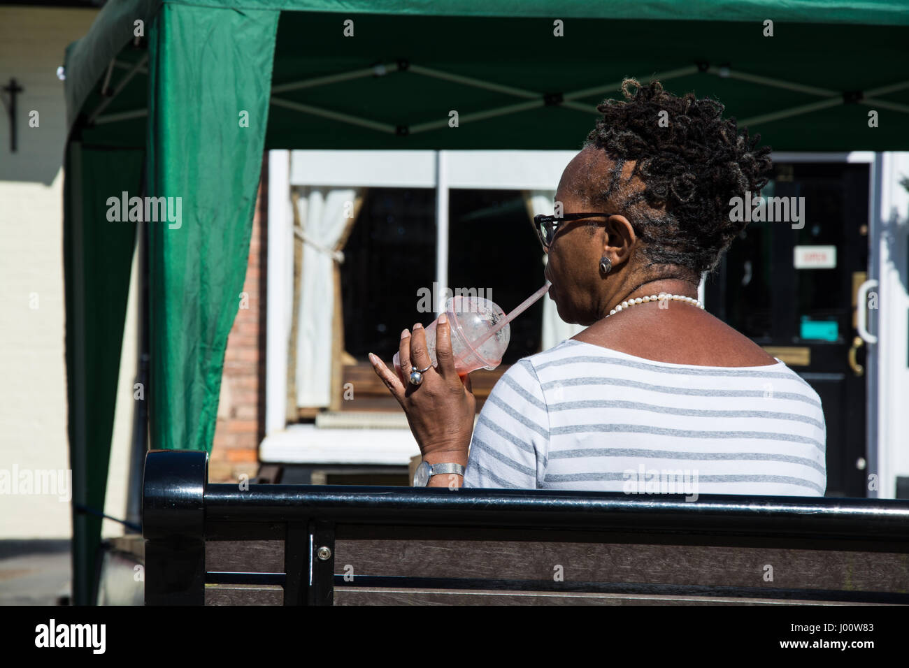 Woman drinking a smoothie enjoying the hottest day of the year in the ...