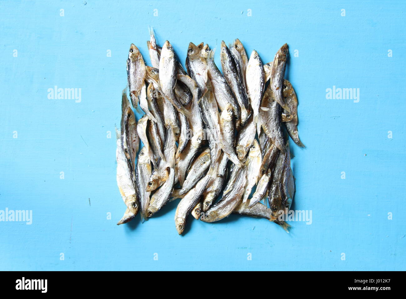 Sun dried fish on a blue surface Stock Photo - Alamy