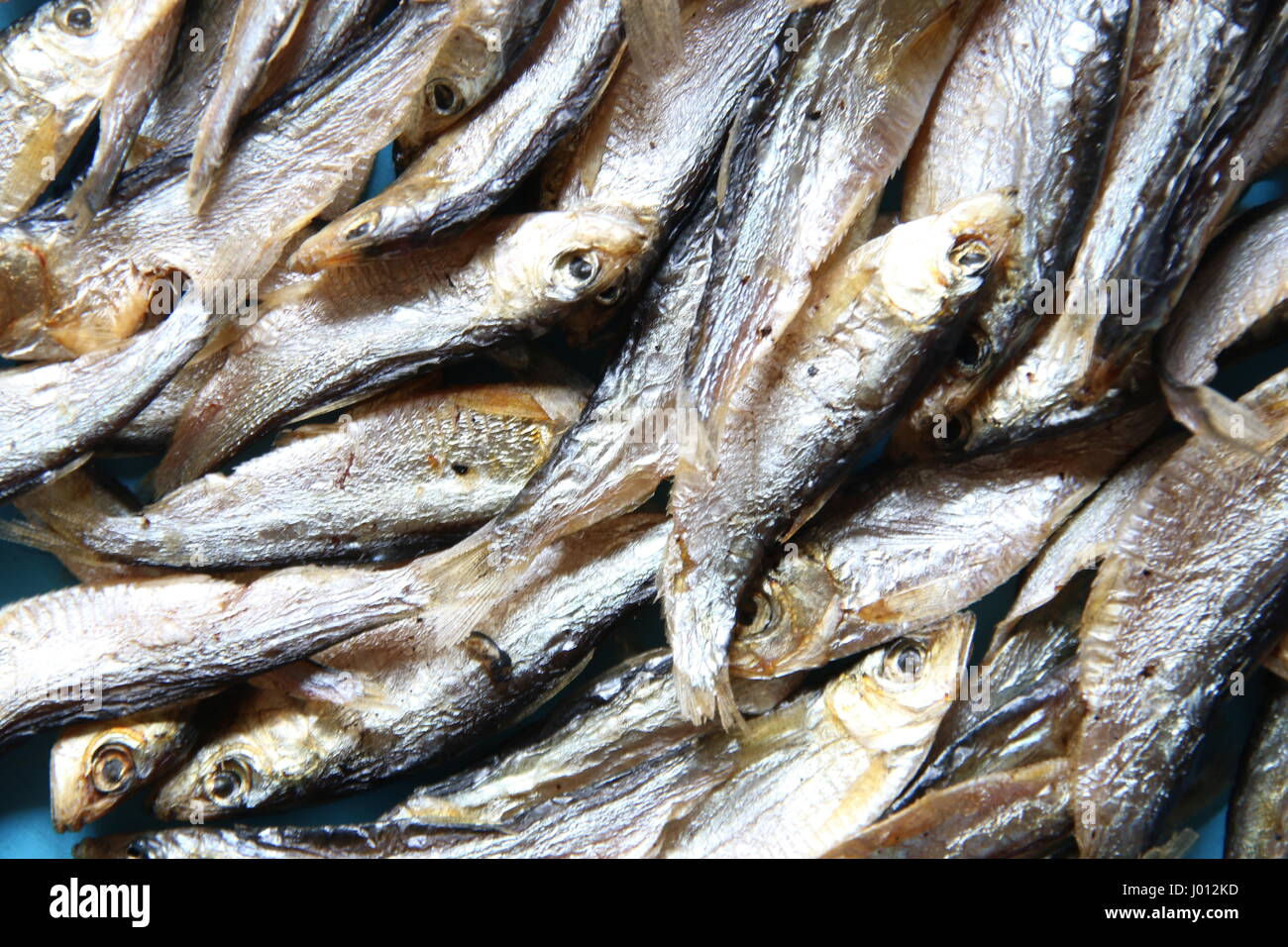 Sun dried fish on a blue surface Stock Photo - Alamy