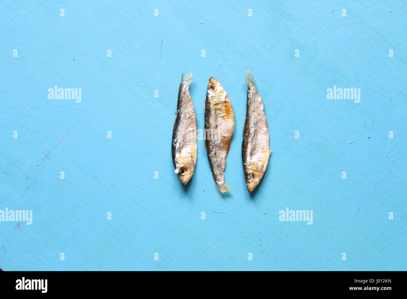 Sun dried fish on a blue surface Stock Photo - Alamy