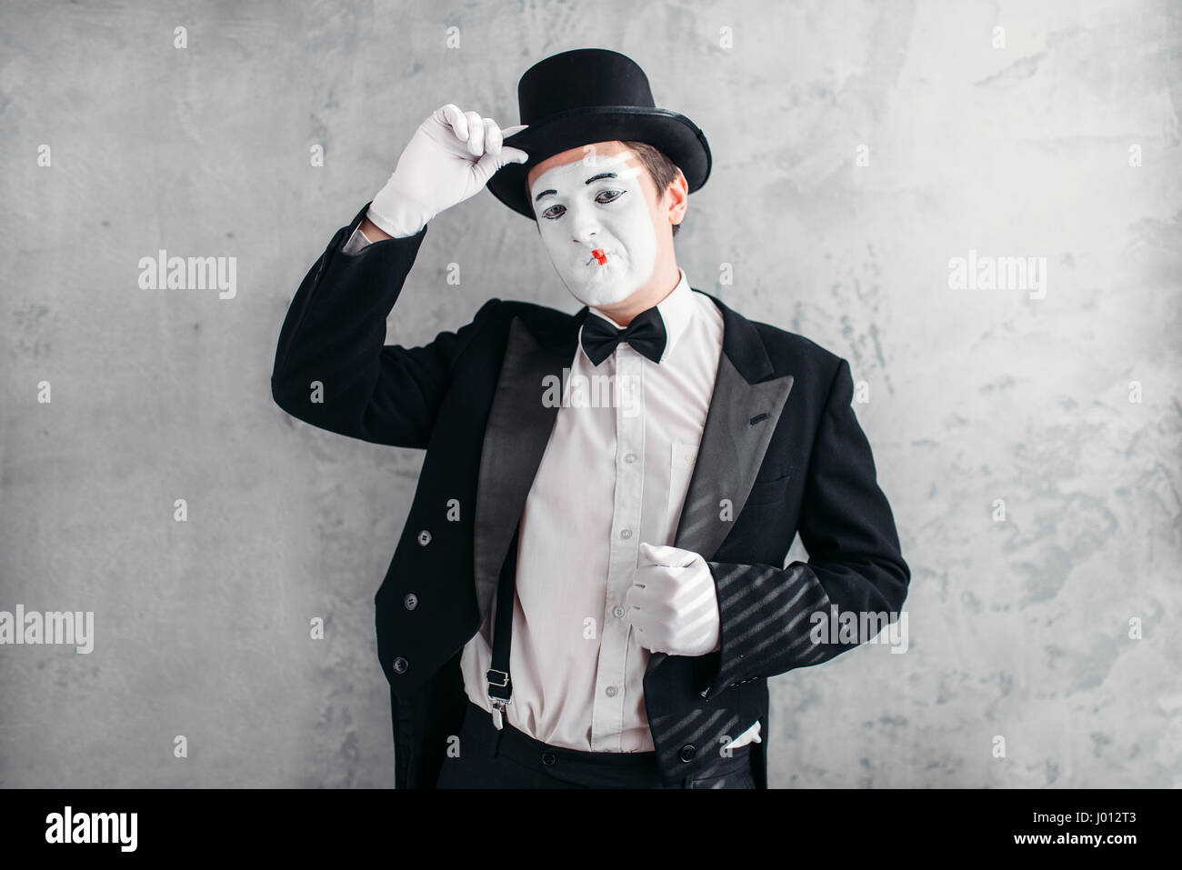 Funny comedy actor with makeup face. Pantomime in suit, gloves and hat ...