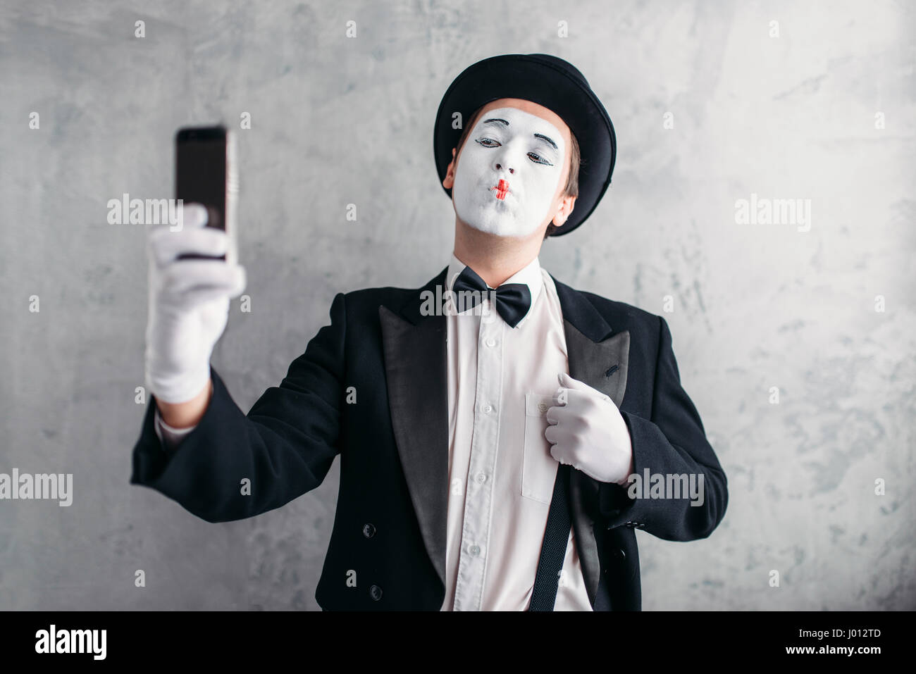 Pantomime actor with makeup mask makes selfie on camera. Comedy artist ...