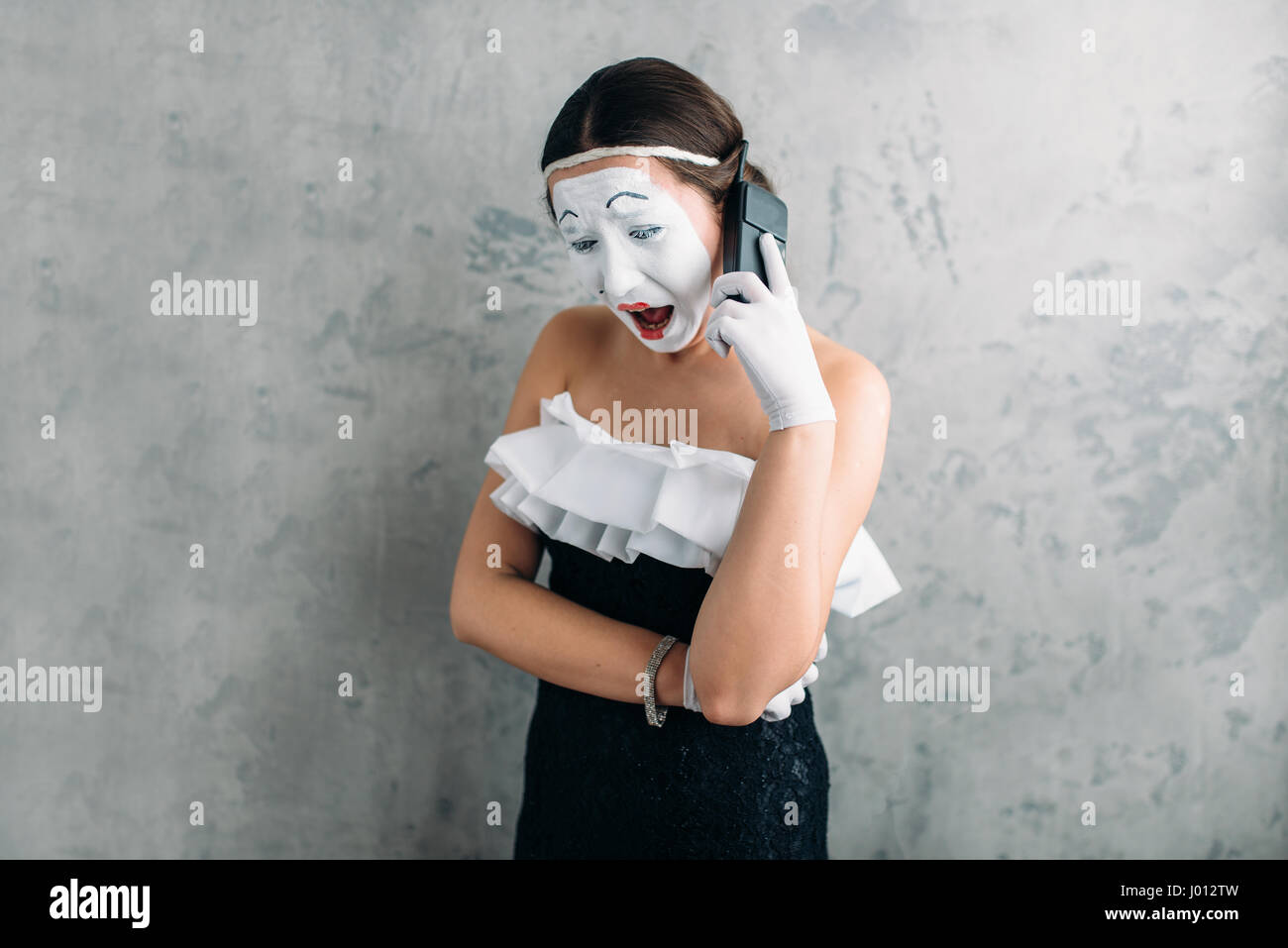 Mime actress performing with mobile phone. Comedy female artist posing ...