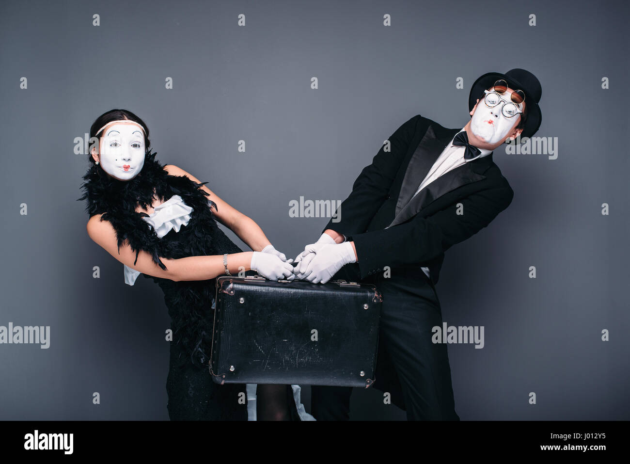 Mime actor and actress performing with suitcase. Pantomime theater ...