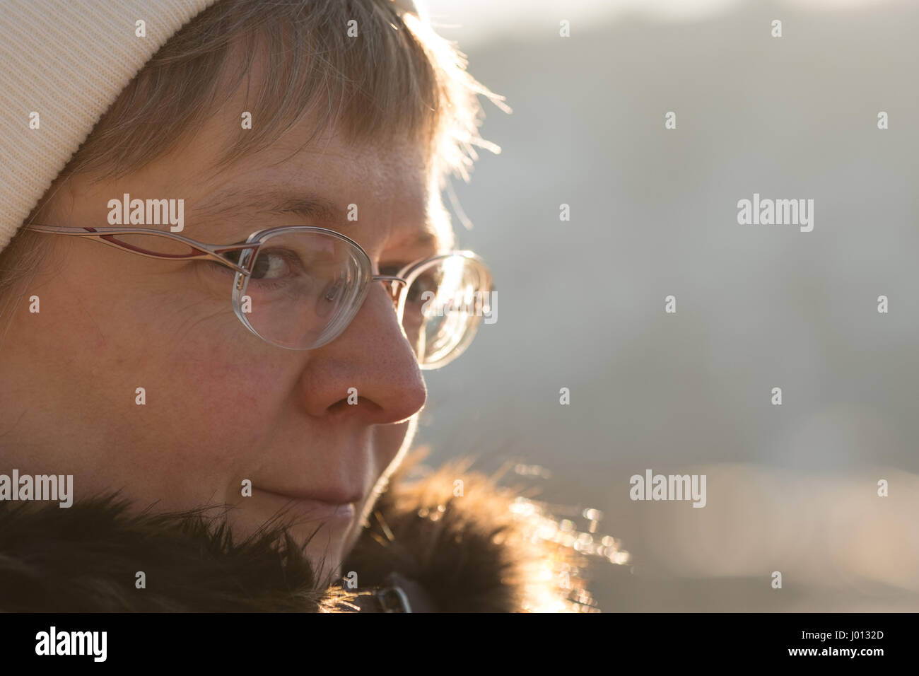 Cheerfull looking fair woman with glasses in backlit Stock Photo - Alamy
