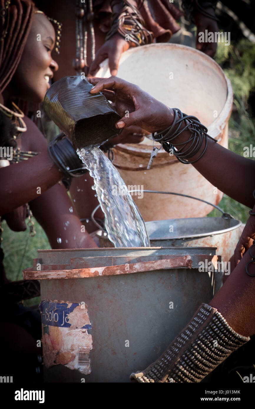 Close up of Himba pouring precious water in the bucket Stock Photo - Alamy