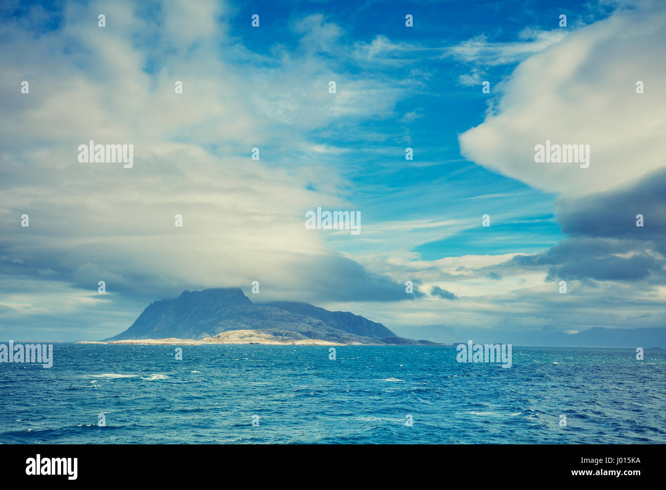 An island with a mountain on the horizon. Beautiful landscape, blue sky ...