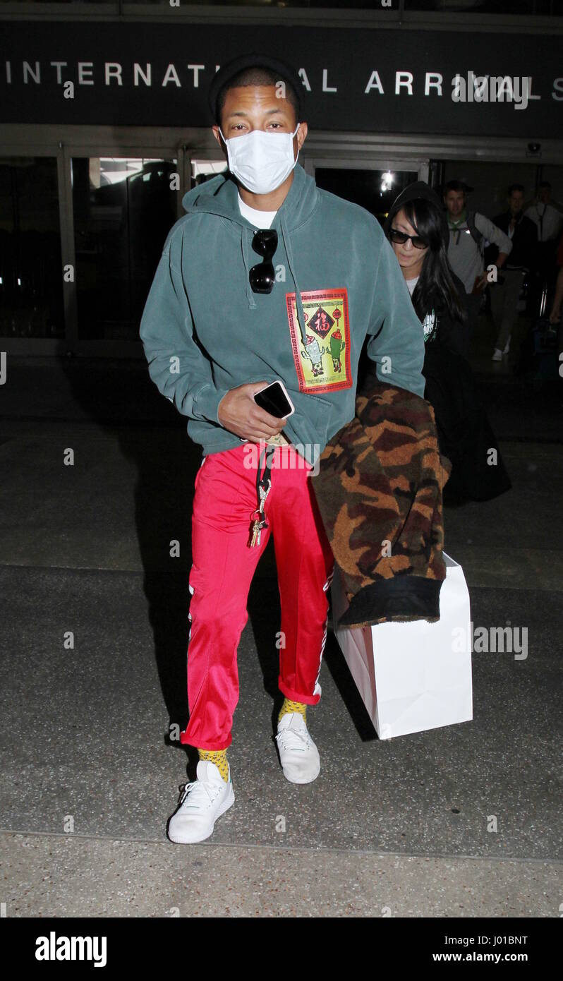 Pharrell Williams wears a surgical face mask as he arrives at Los ...