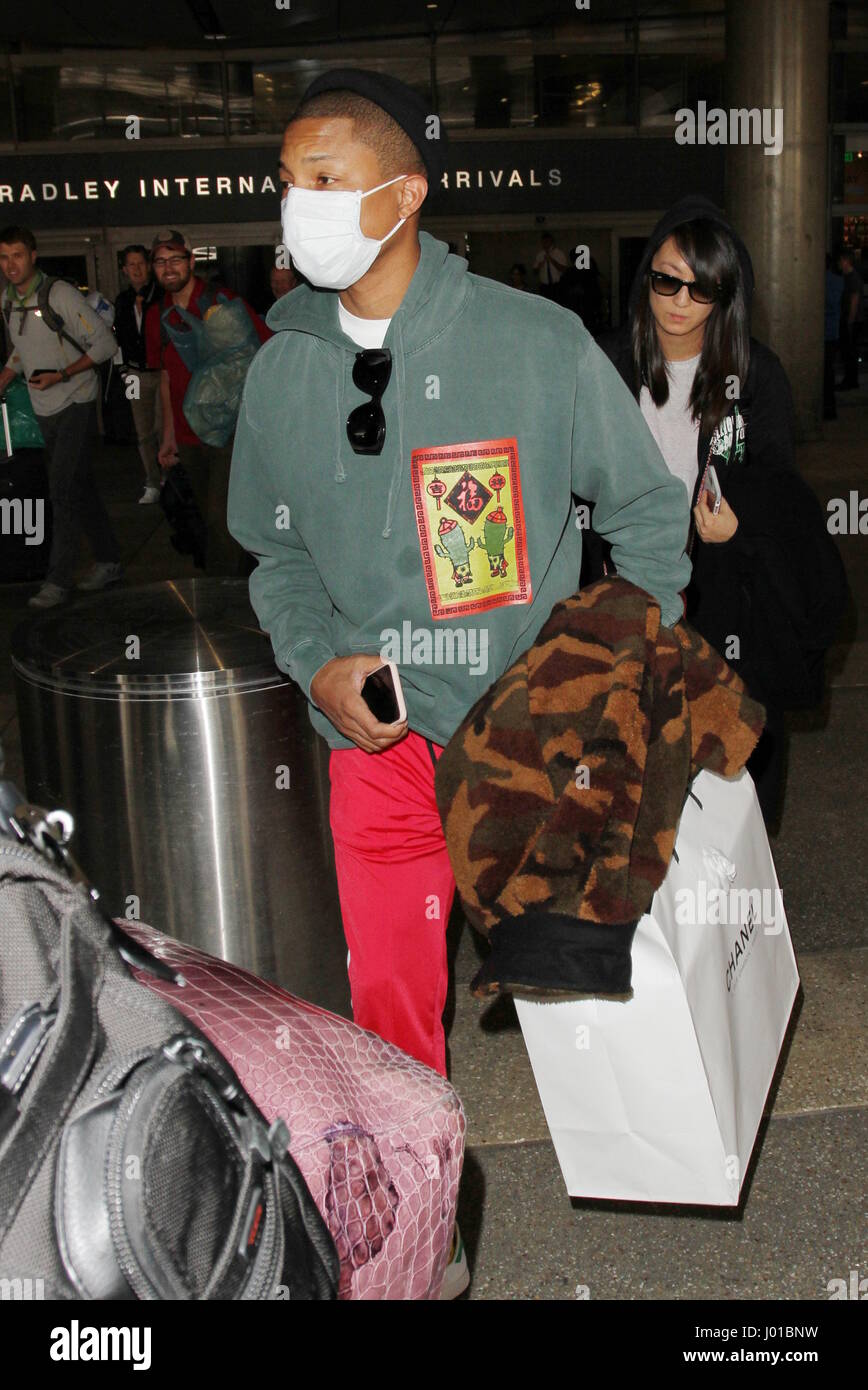 Pharrell Williams wears a surgical face mask as he arrives at Los ...