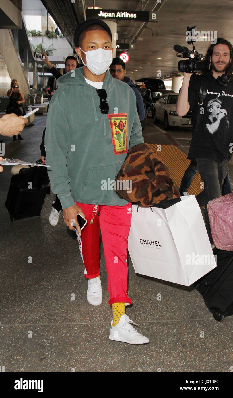 Pharrell Williams wears a surgical face mask as he arrives at Los ...