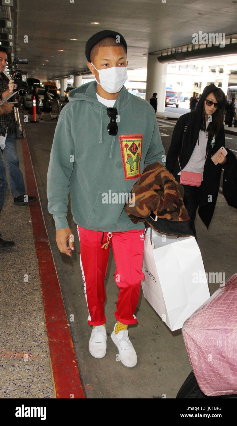 Pharrell Williams wears a surgical face mask as he arrives at Los ...