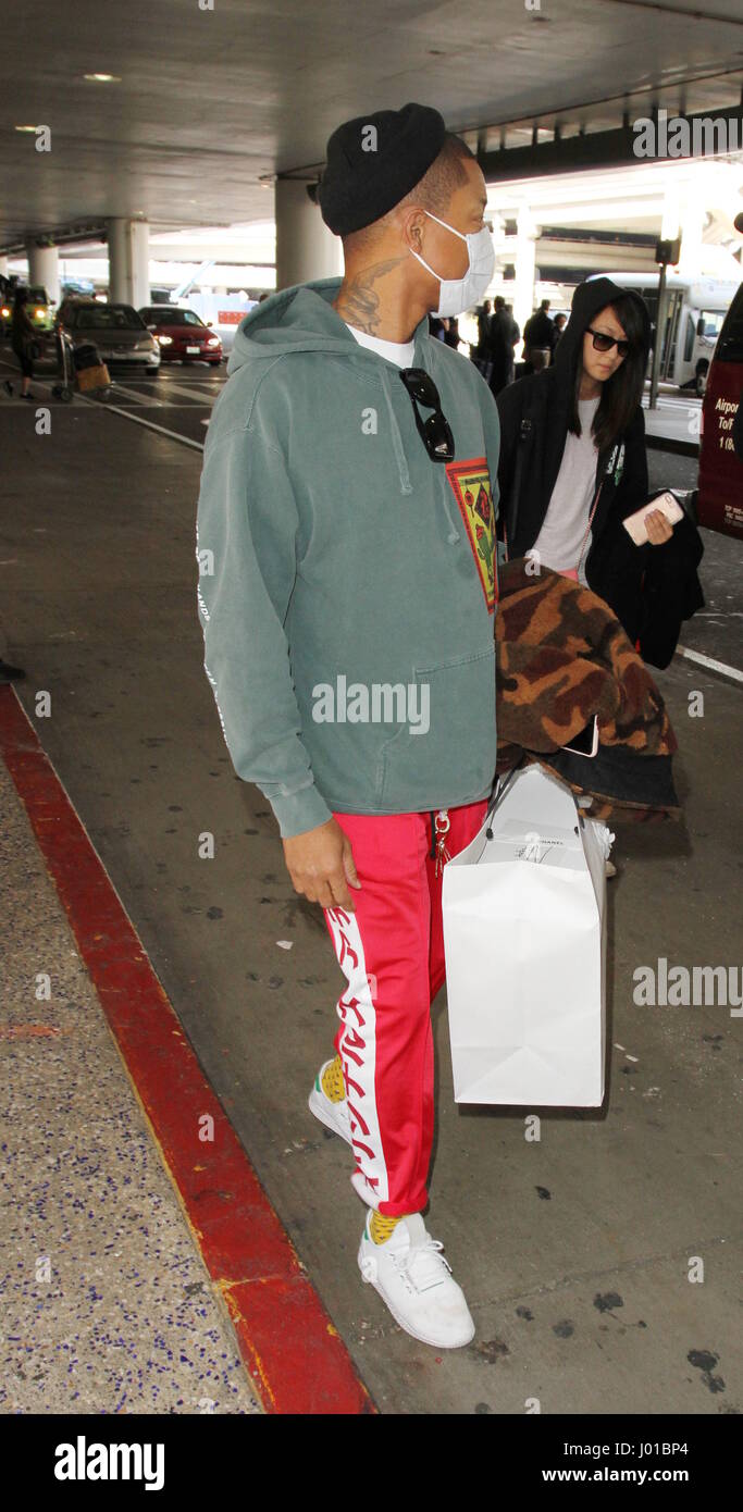 Pharrell Williams wears a surgical face mask as he arrives at Los ...