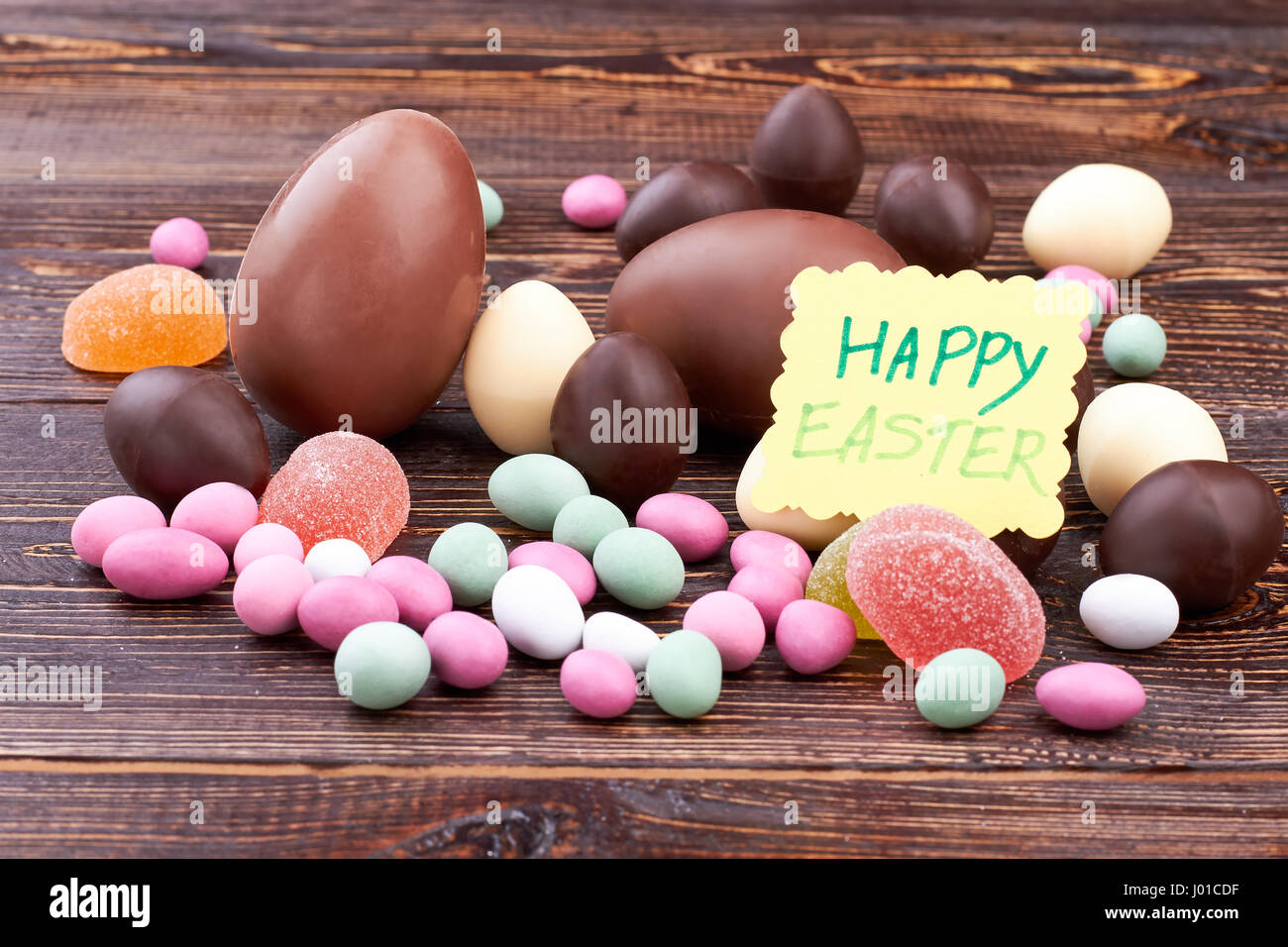 Candies and Happy Easter card. Sweets on brown wood. Homemade Easter ...