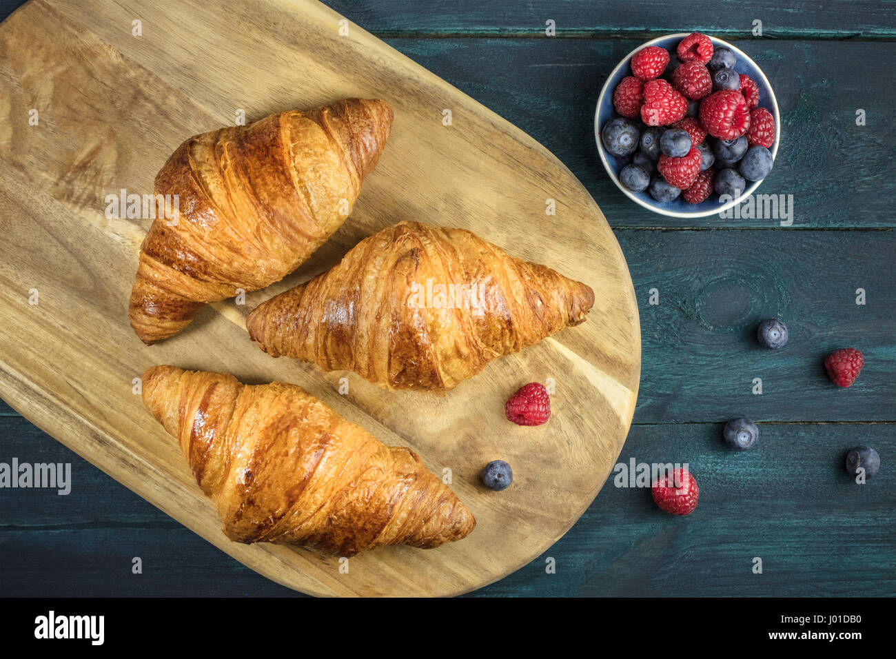 Crunchy French croissants with fresh raspberries and blueberries Stock ...