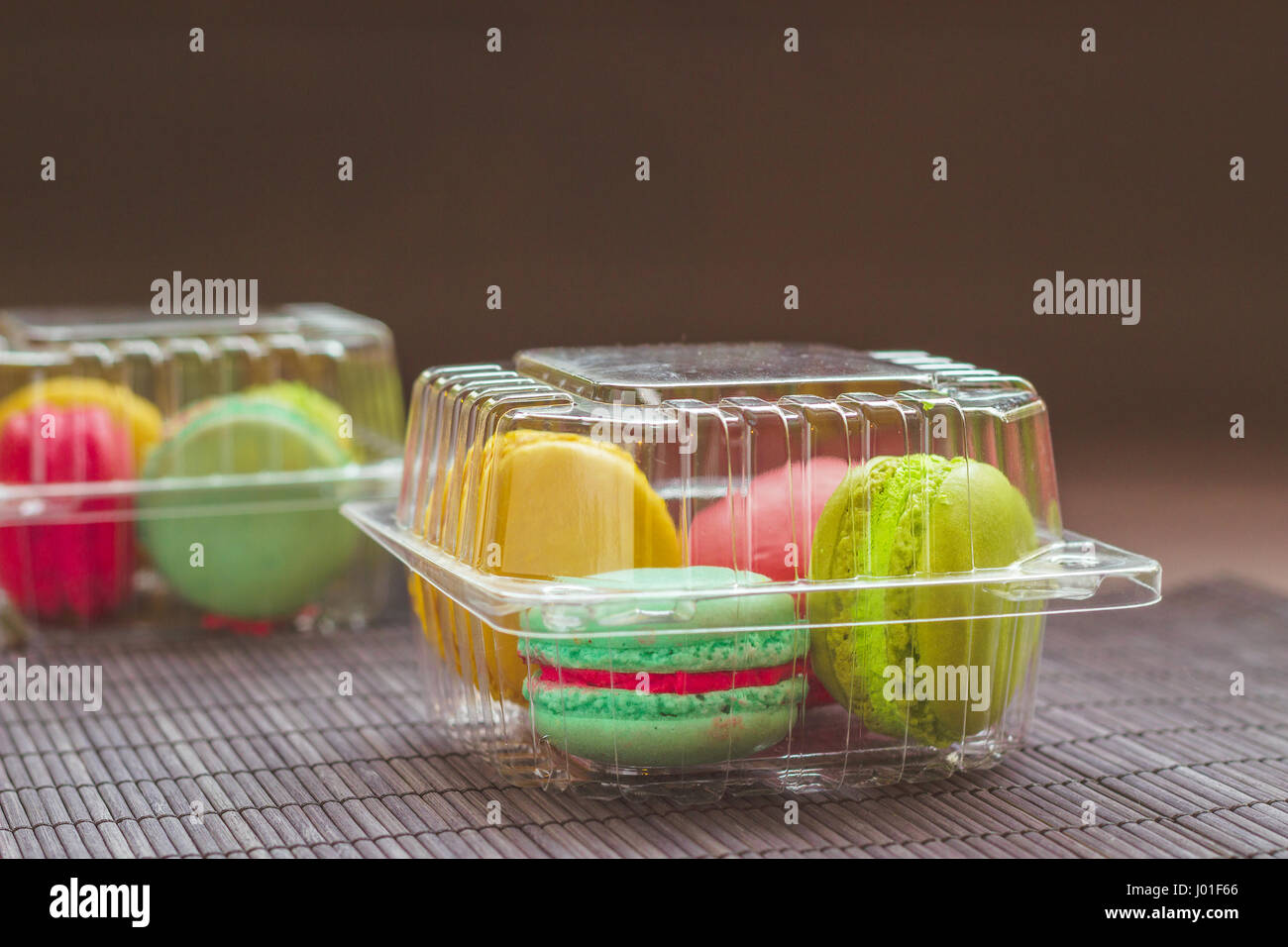 Two plastic boxes with macaroons on the table on dark background Stock ...