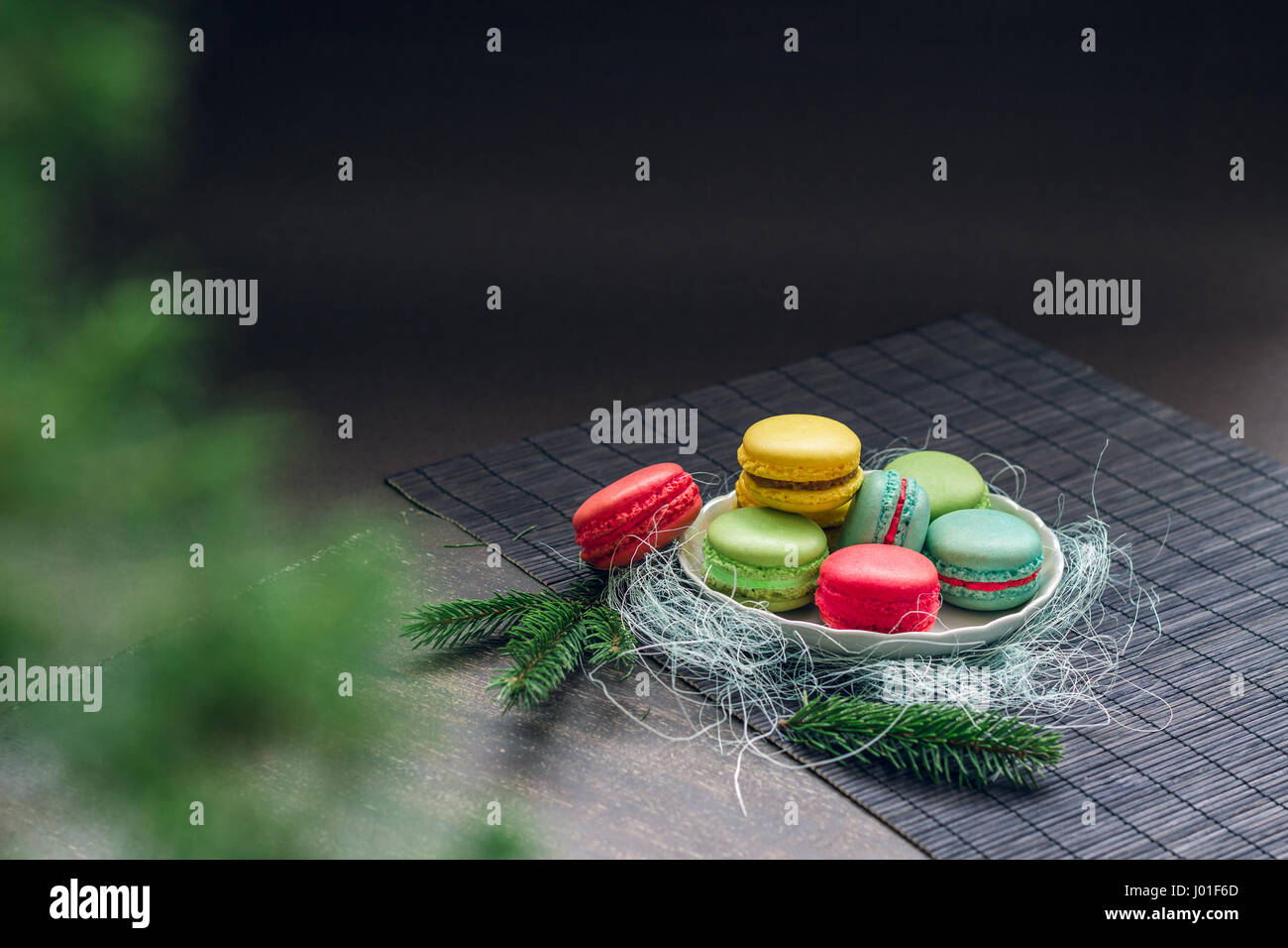 Winter still life with traditional French macaroons on the small plate ...