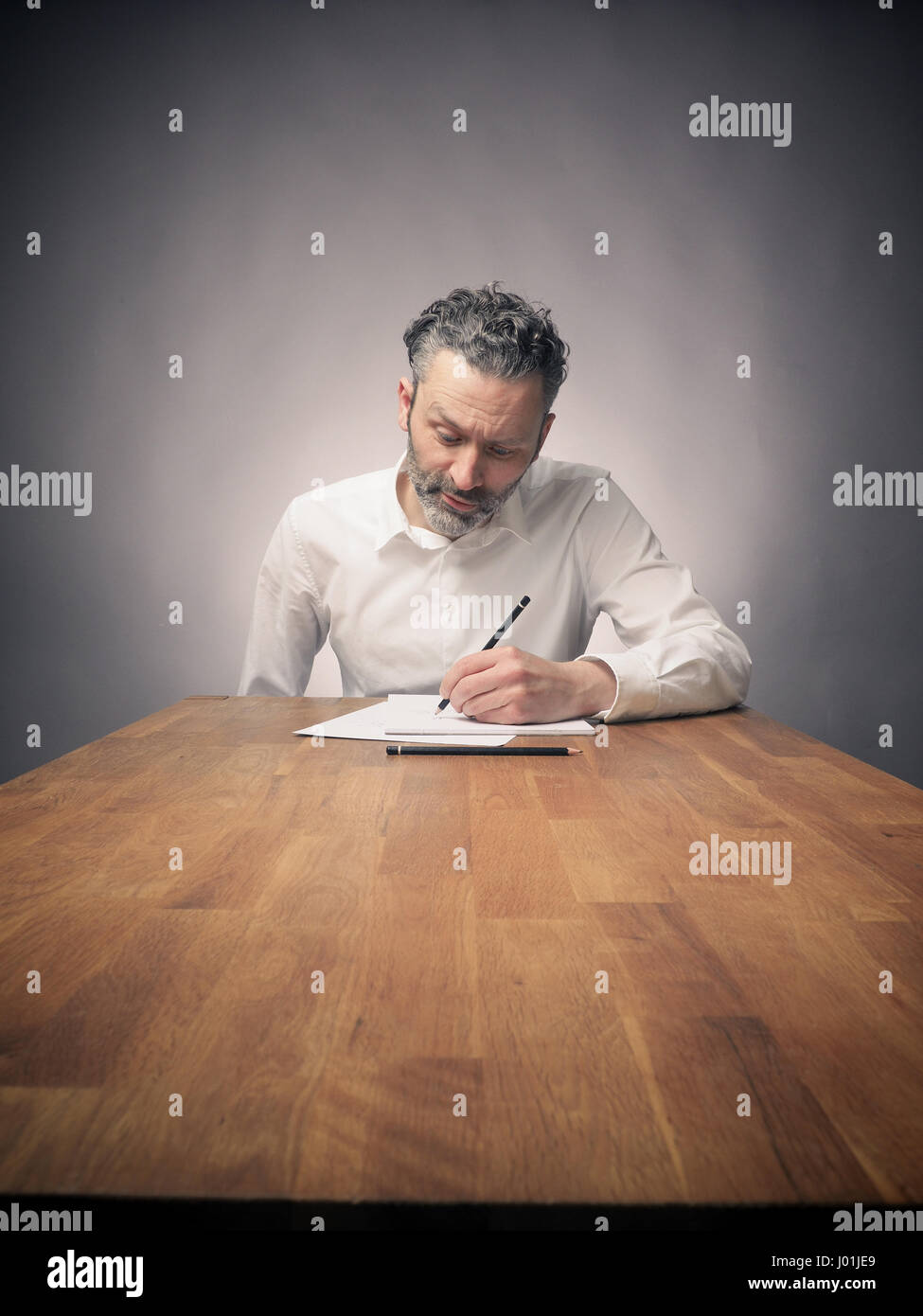 Crazy business man working on a wooden office table, wide angle shot ...