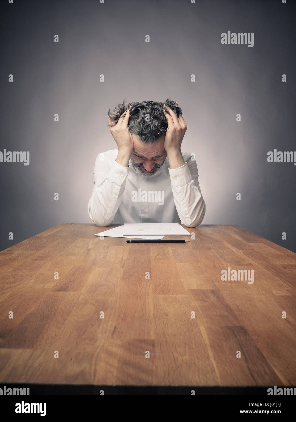Crazy business man working on a wooden office table, wide angle shot ...