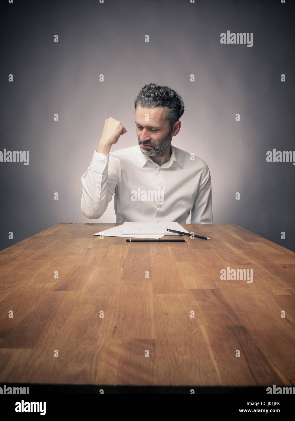 Crazy business man working on a wooden office table, wide angle shot ...