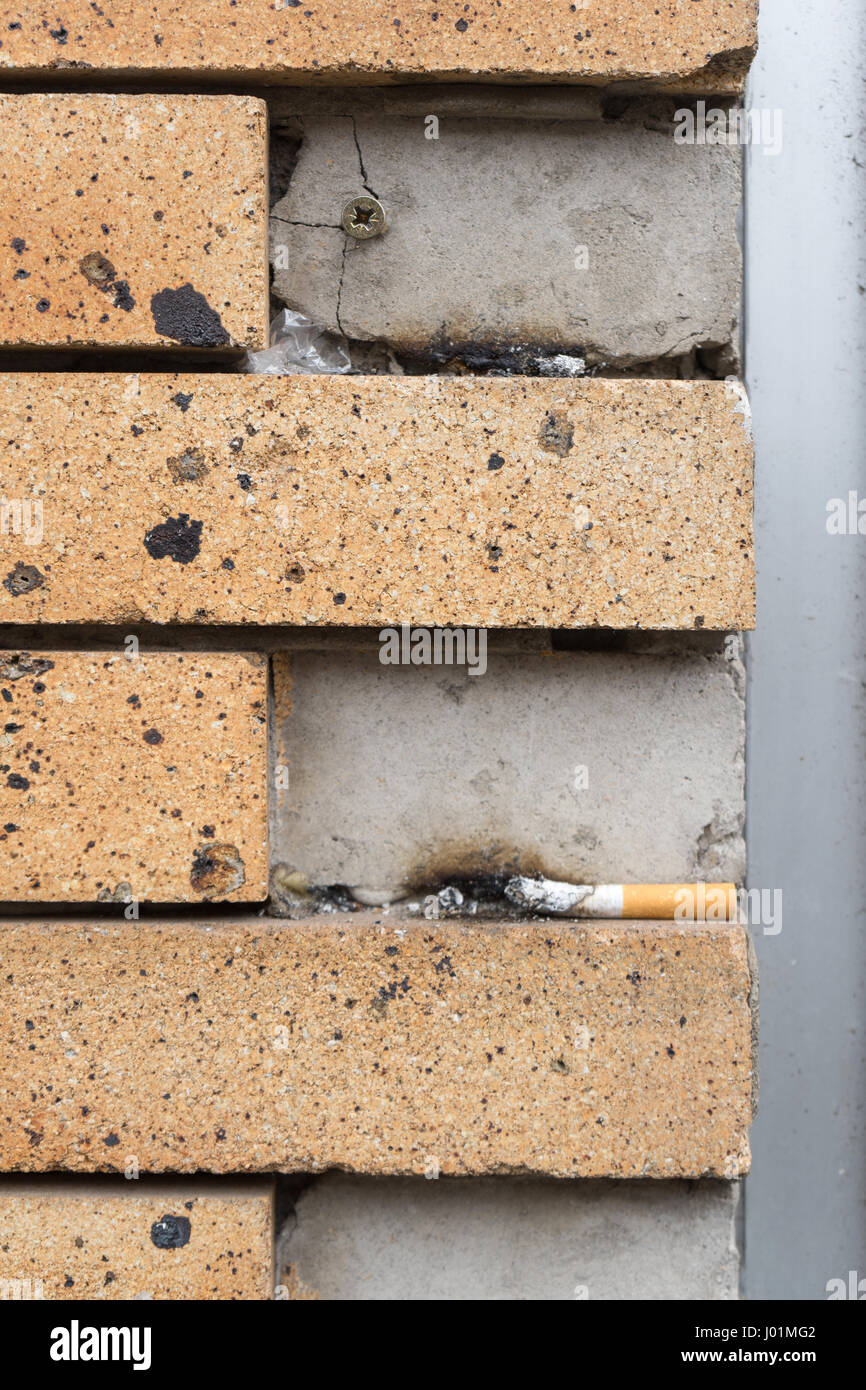 Departing a wall with cigarette butt Stock Photo - Alamy