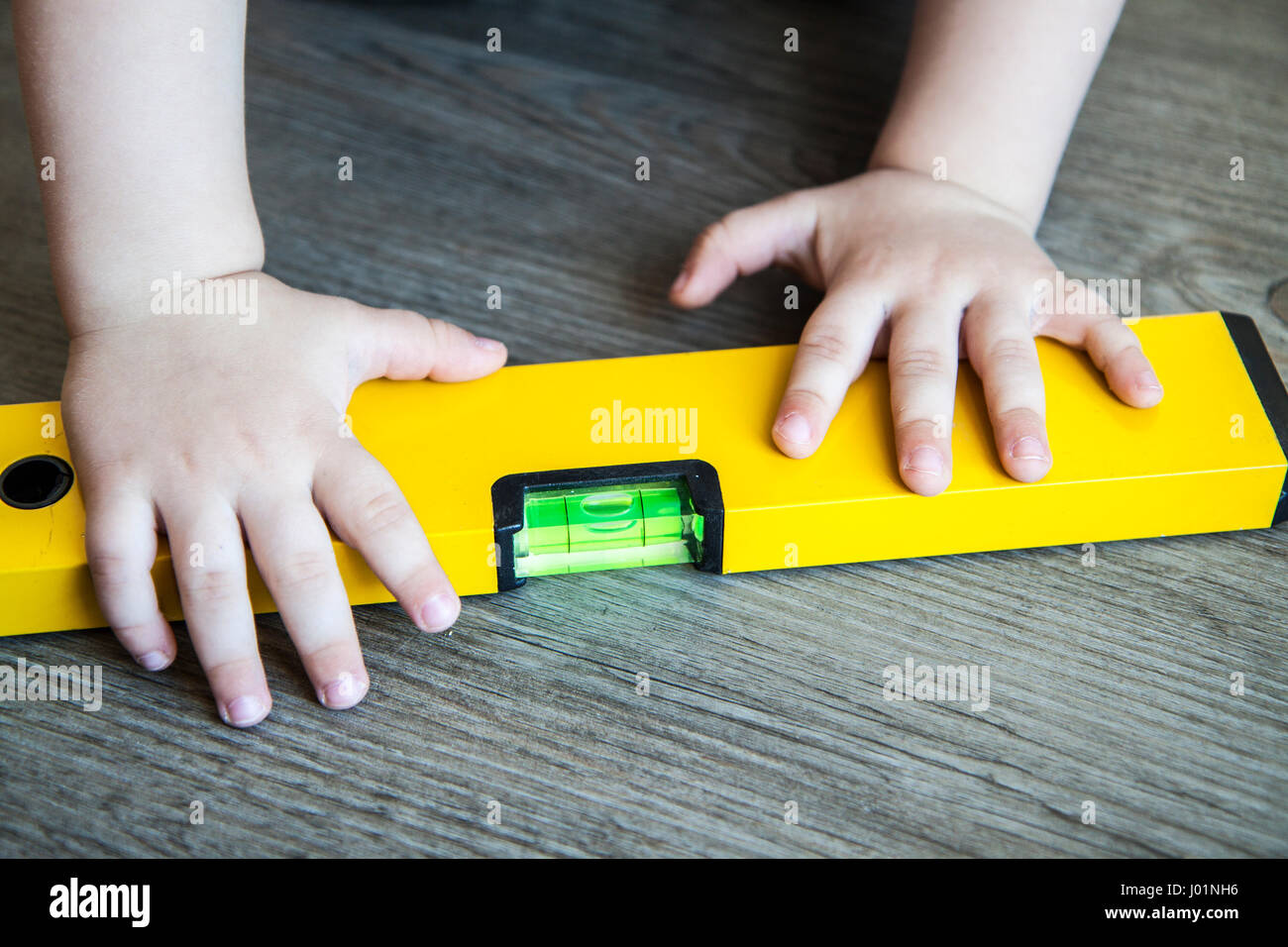 spirit level in young boy hand - child with waterlevel, wood floor ...