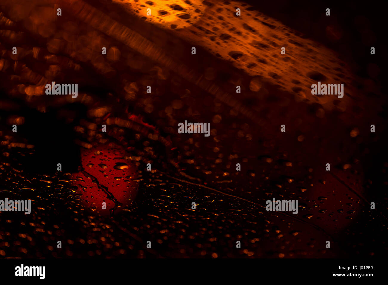 View of the modern city through the window on a very dark stormy night ...