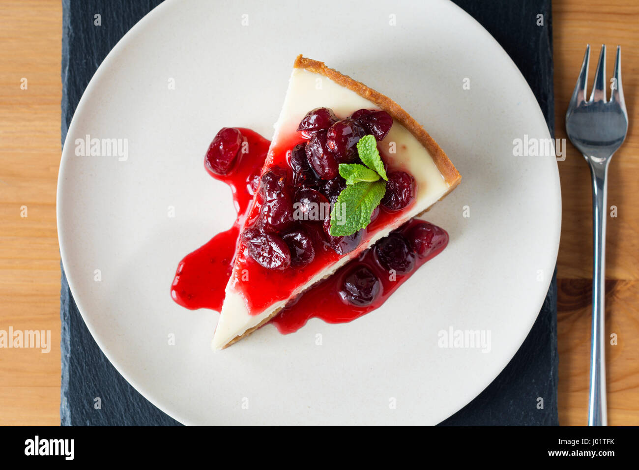Cheesecake on plate with cherry sauce, top view Stock Photo - Alamy