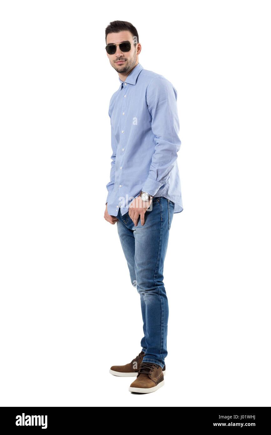 Relaxed smart casual young man wearing sunglasses looking at camera ...