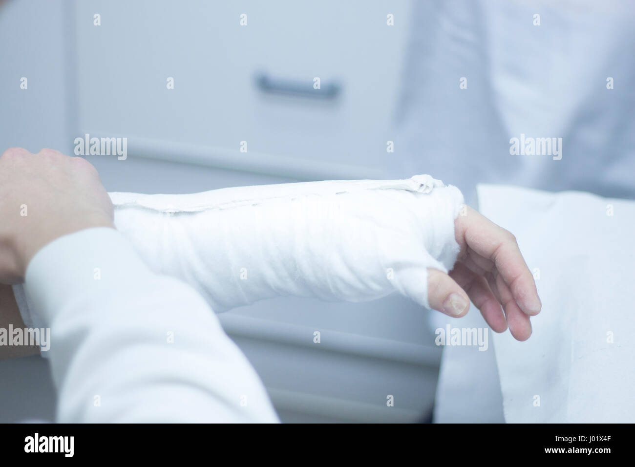 Doctor applying a plaster cast and bandages to patient forearm and ...