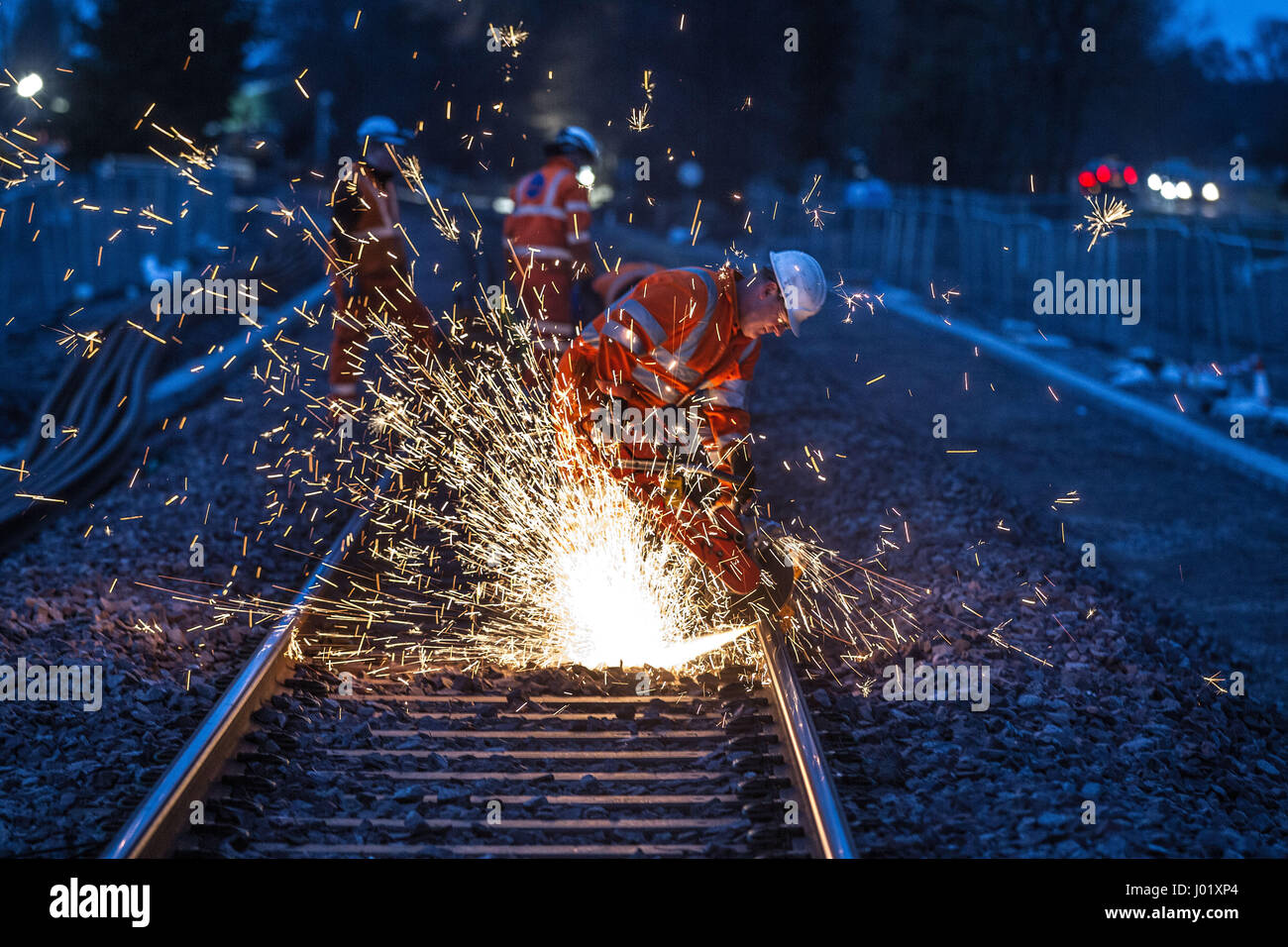 Rail workers cutting and laying new tracks on night shift Stock Photo ...
