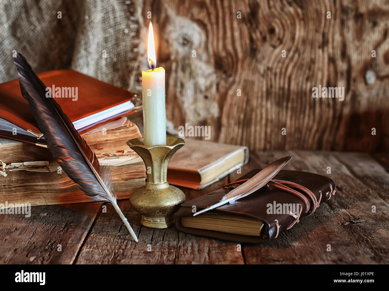 feather and book novel close to the a candle Stock Photo - Alamy