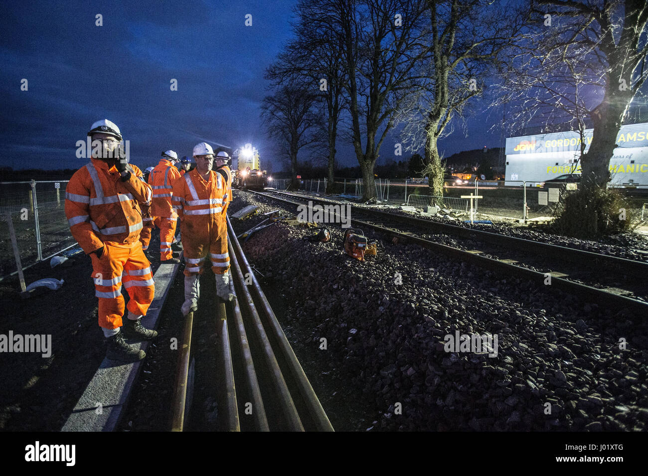 Rail workers cutting and laying new tracks on night shift Stock Photo ...