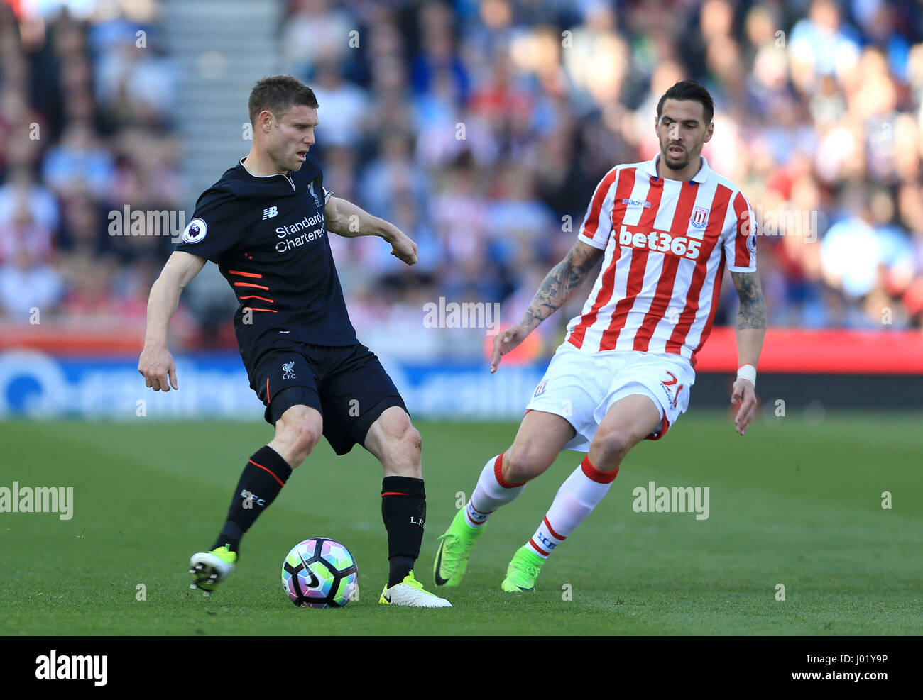 Liverpool's James Milner (left) and Stoke City's Geoff Cameron battle ...