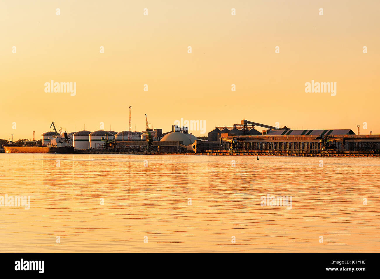 Oil tanks in Baltic sea at Port in Klaipeda, Lithuania. Magic golden ...