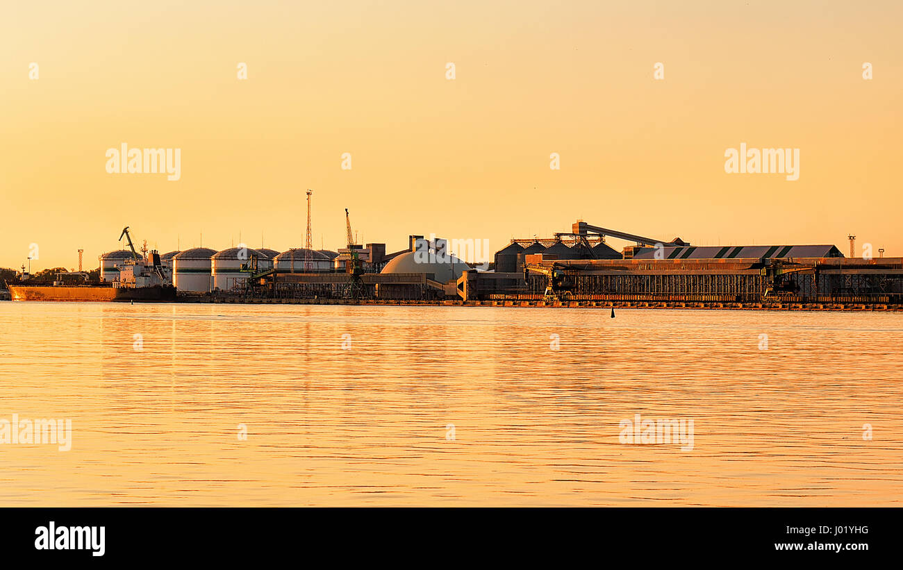 Oil tanks in Baltic sea at Port of Klaipeda, Lithuania. Magic golden ...