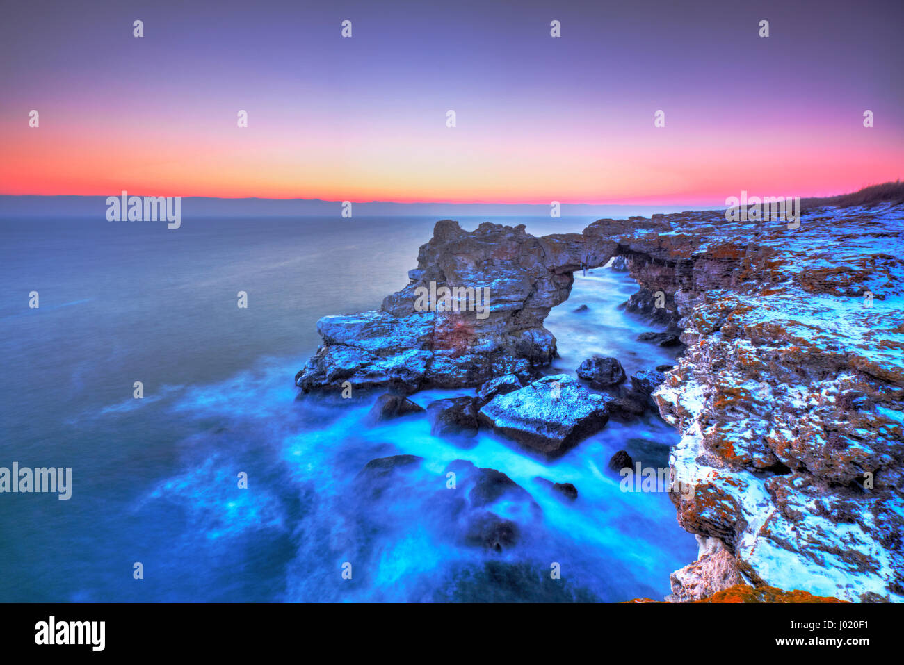 Beautiful sunrise over the sea and stone arch Stock Photo - Alamy