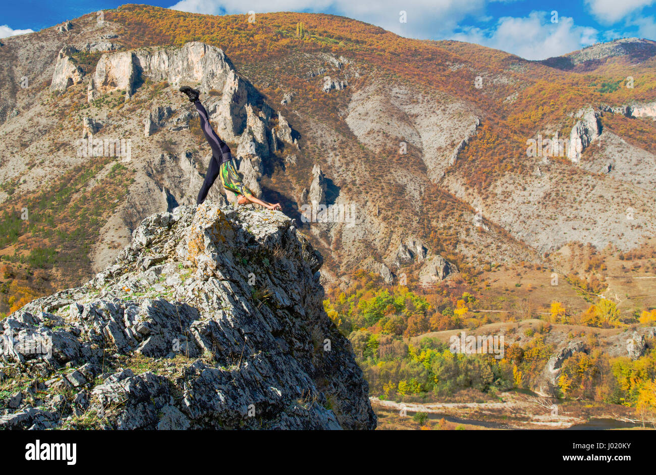 Young lady in yoga position on the rocks in mountain Stock Photo - Alamy