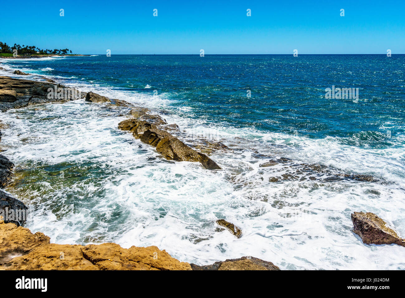 Waves of the Pacific Ocean crashing on the rocks on the shoreline of Ko ...