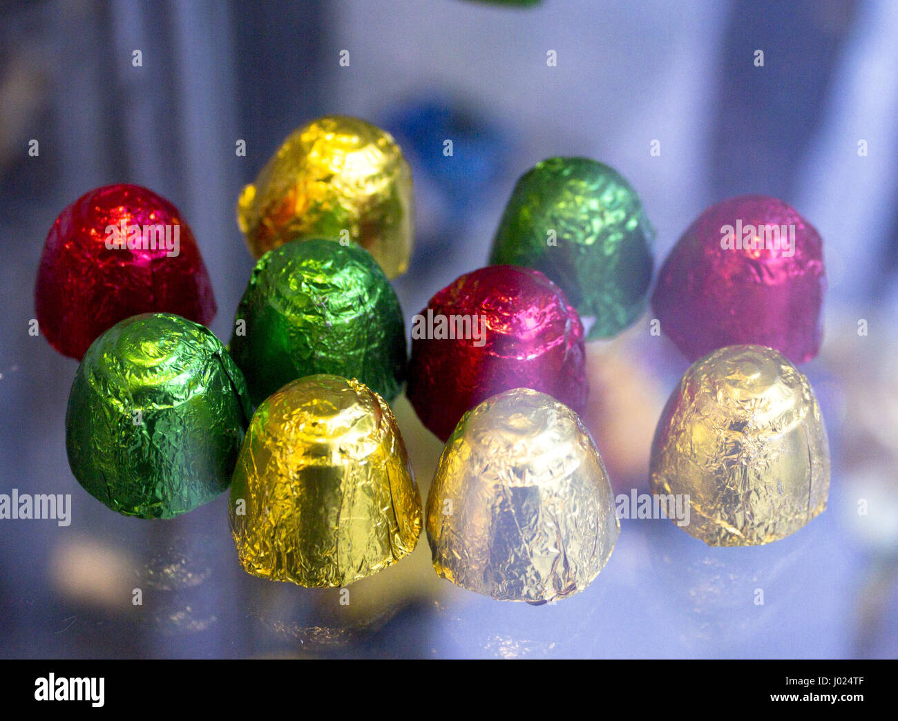 Small chocolates wrapped in metallic paper Stock Photo - Alamy