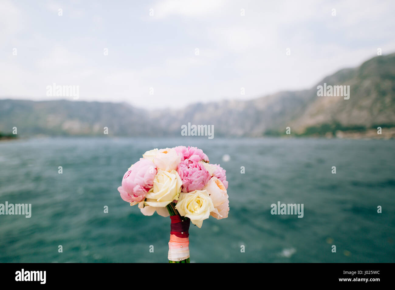 Bridal bouquet of roses and peonies on the background of water. Bay of ...