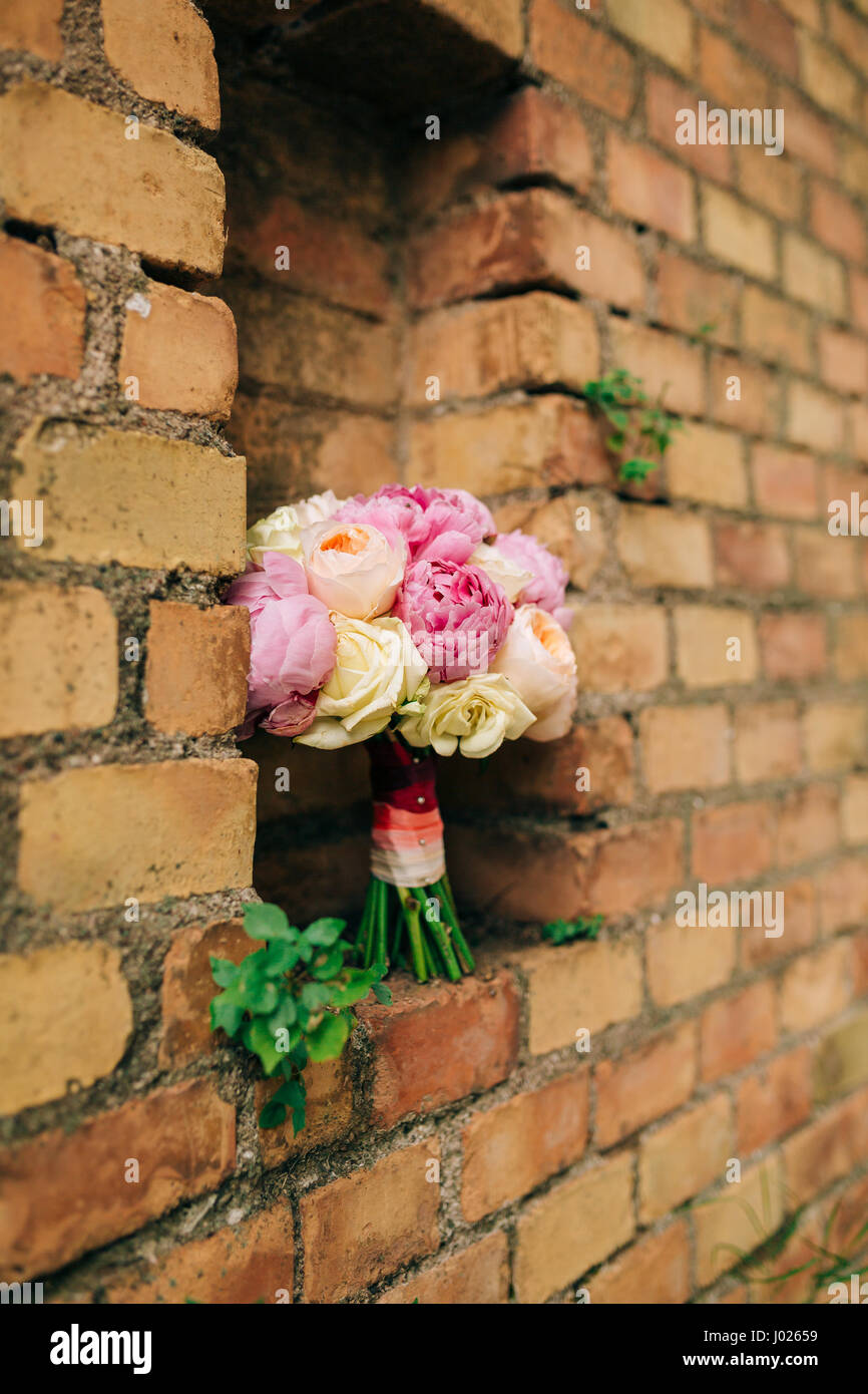 Bouquet of peonies on the background of the stone wall of red brick ...