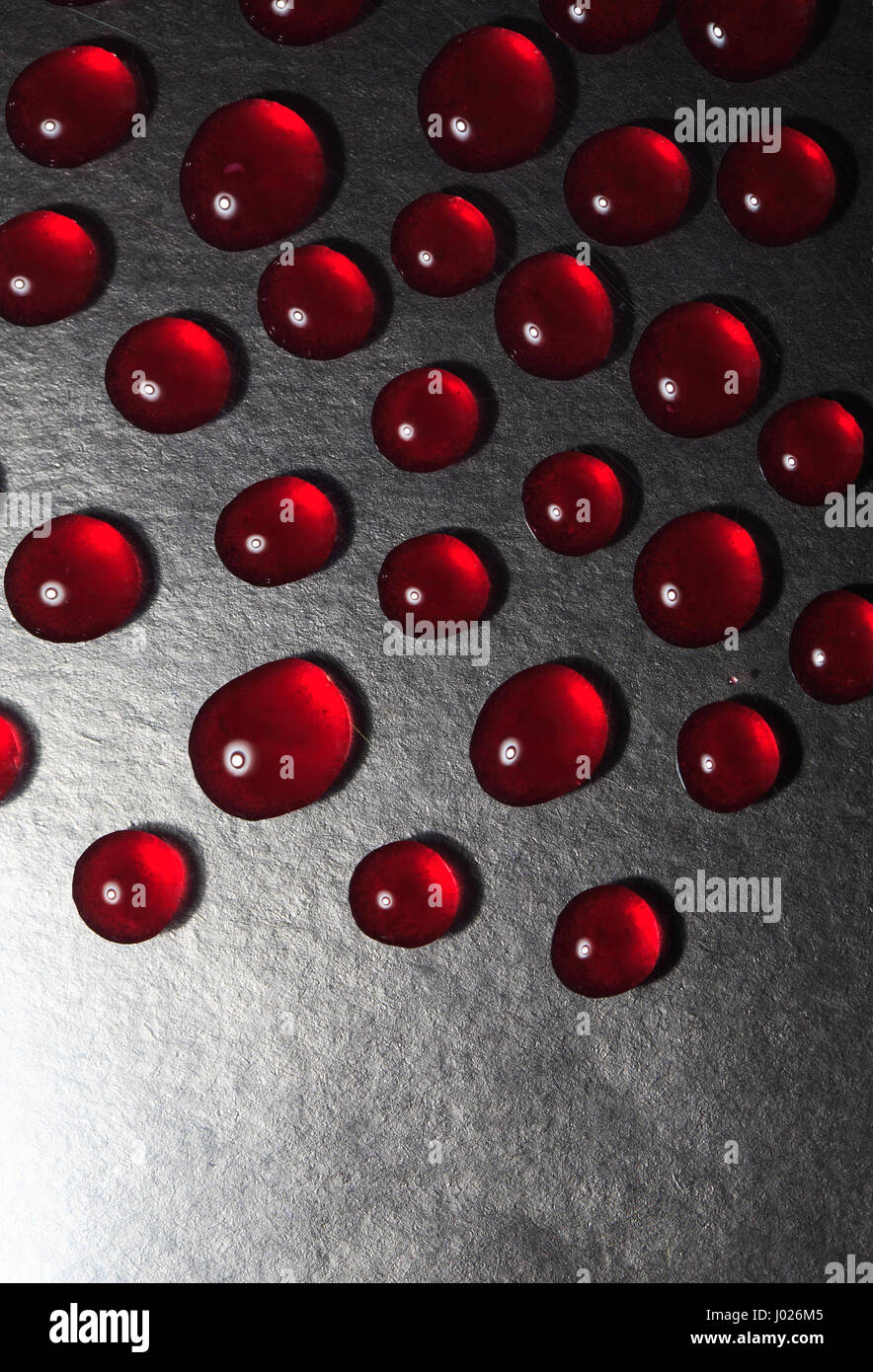 Closeup of set of red drops on dark background Stock Photo - Alamy