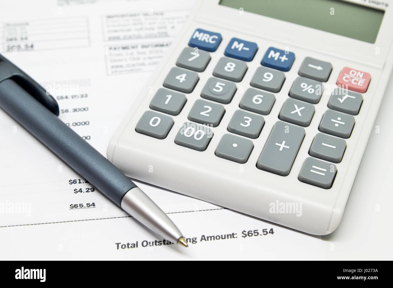 Calculating numbers for bill with pen and calculator Stock Photo - Alamy