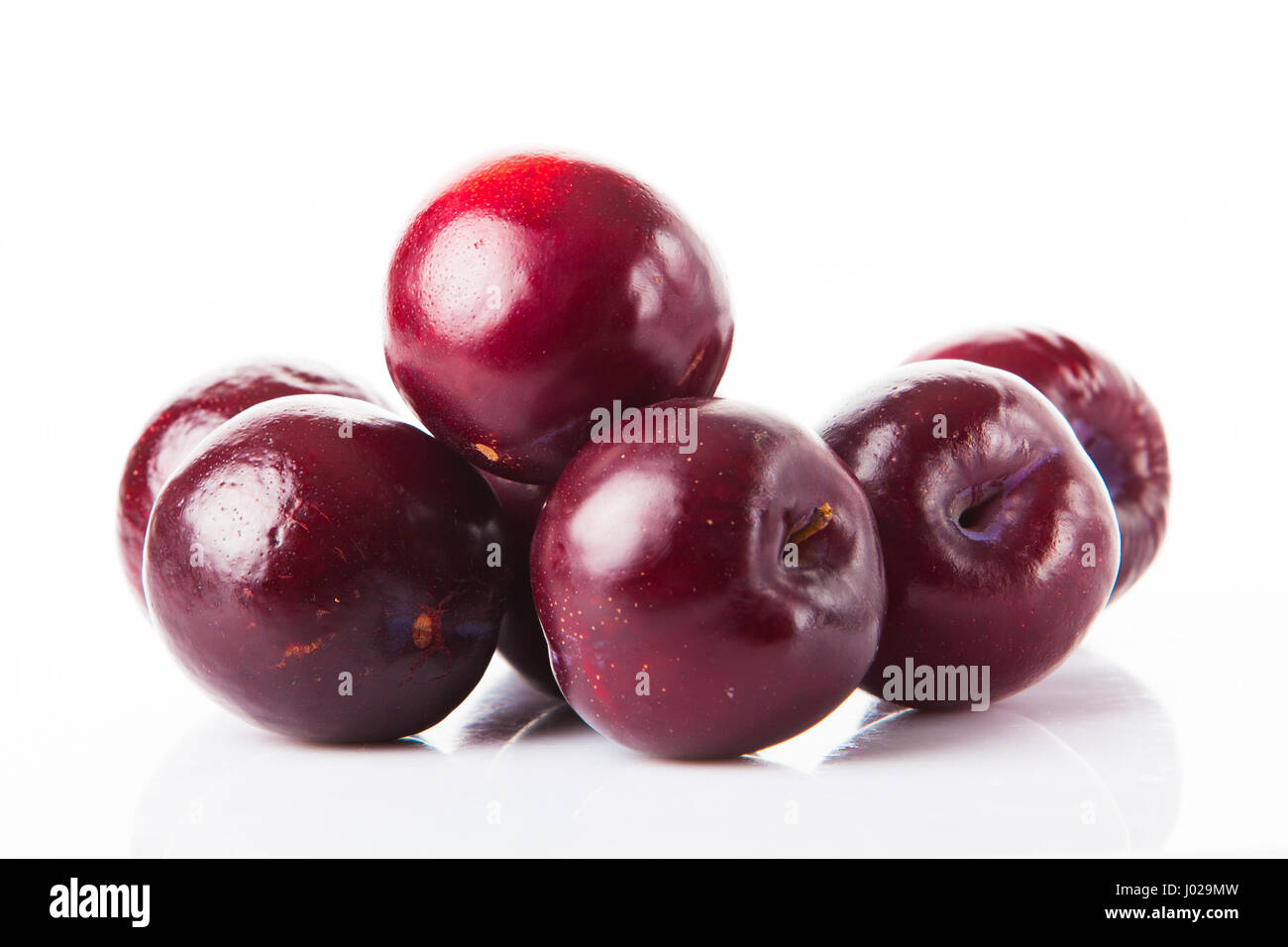 Three whole red plums on white background hi-res stock photography and ...