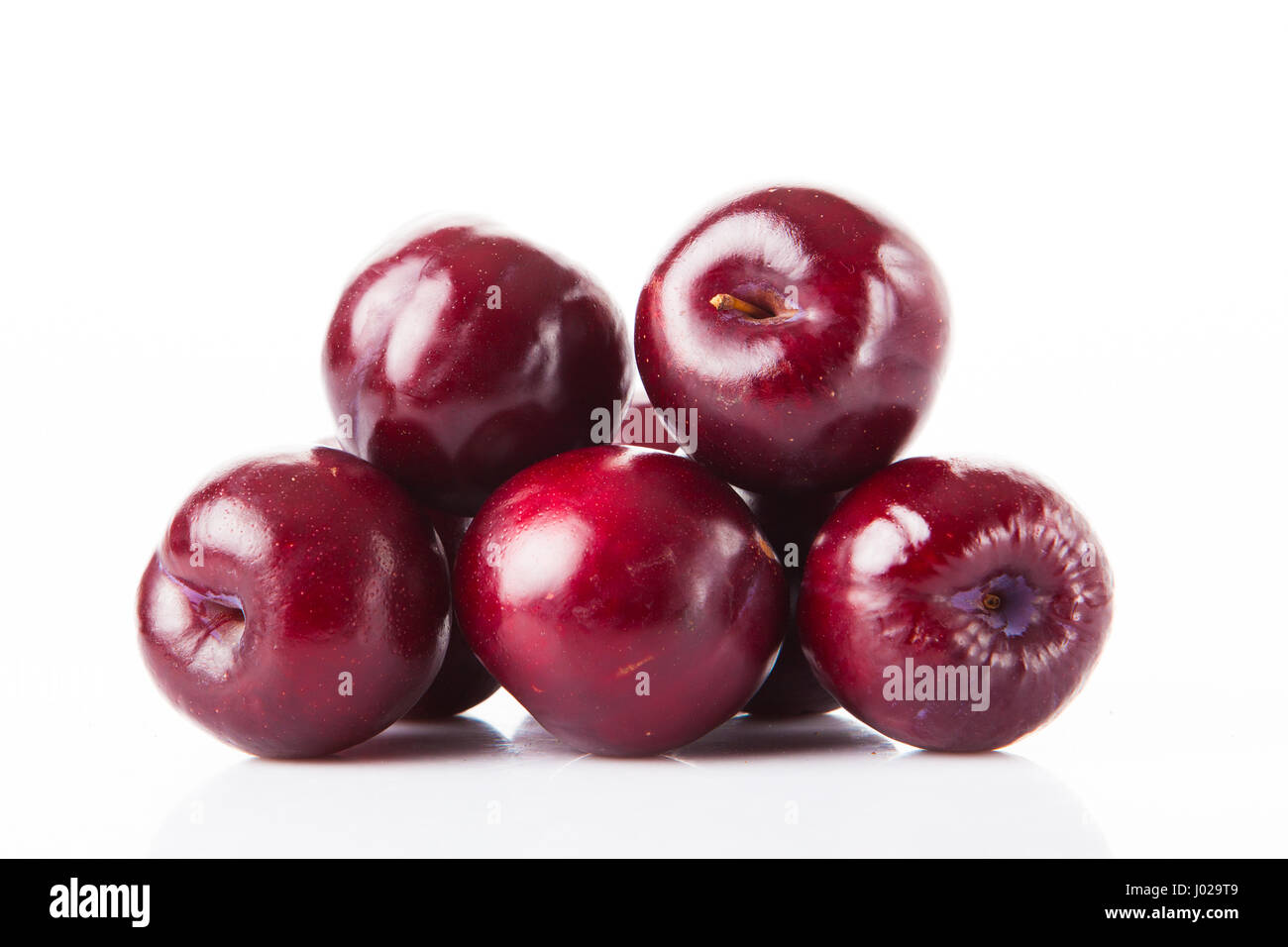 Three whole red plums on white background hi-res stock photography and ...