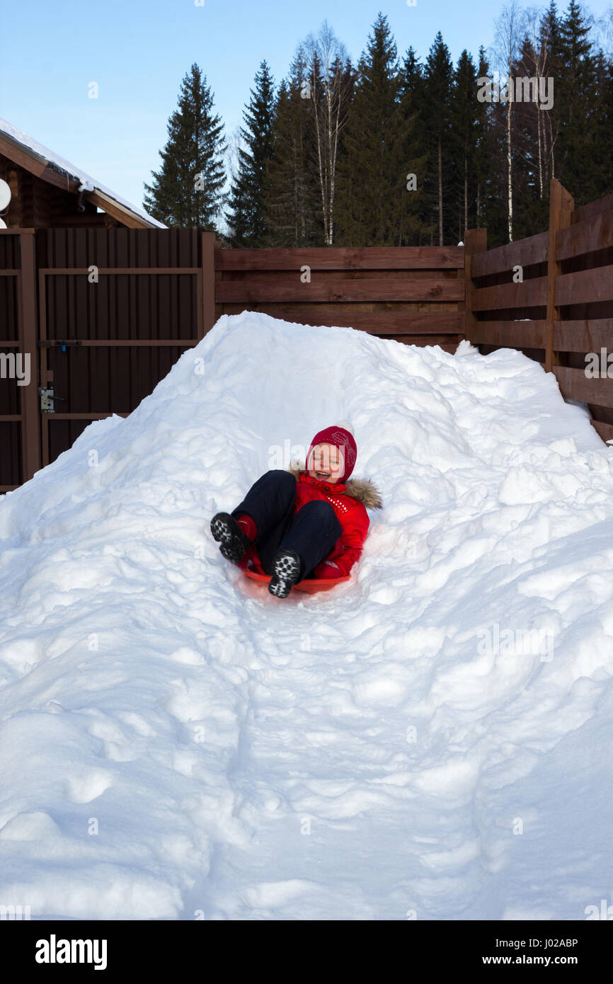 girl slides down from the snow hill on saucer Stock Photo - Alamy