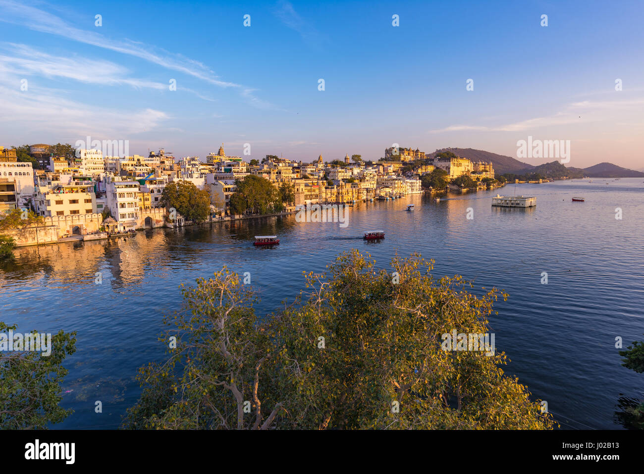 The famous city palace on Lake Pichola reflecting sunset light. Udaipur ...