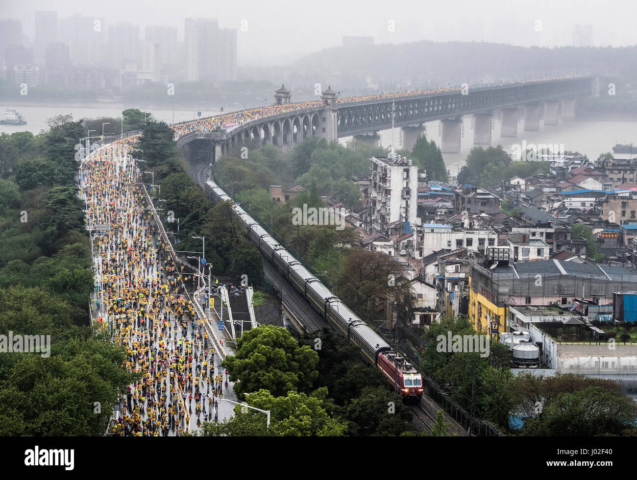 Wuhan. 9th Apr, 2017. Runners run on the Yangtze River Bridge during ...