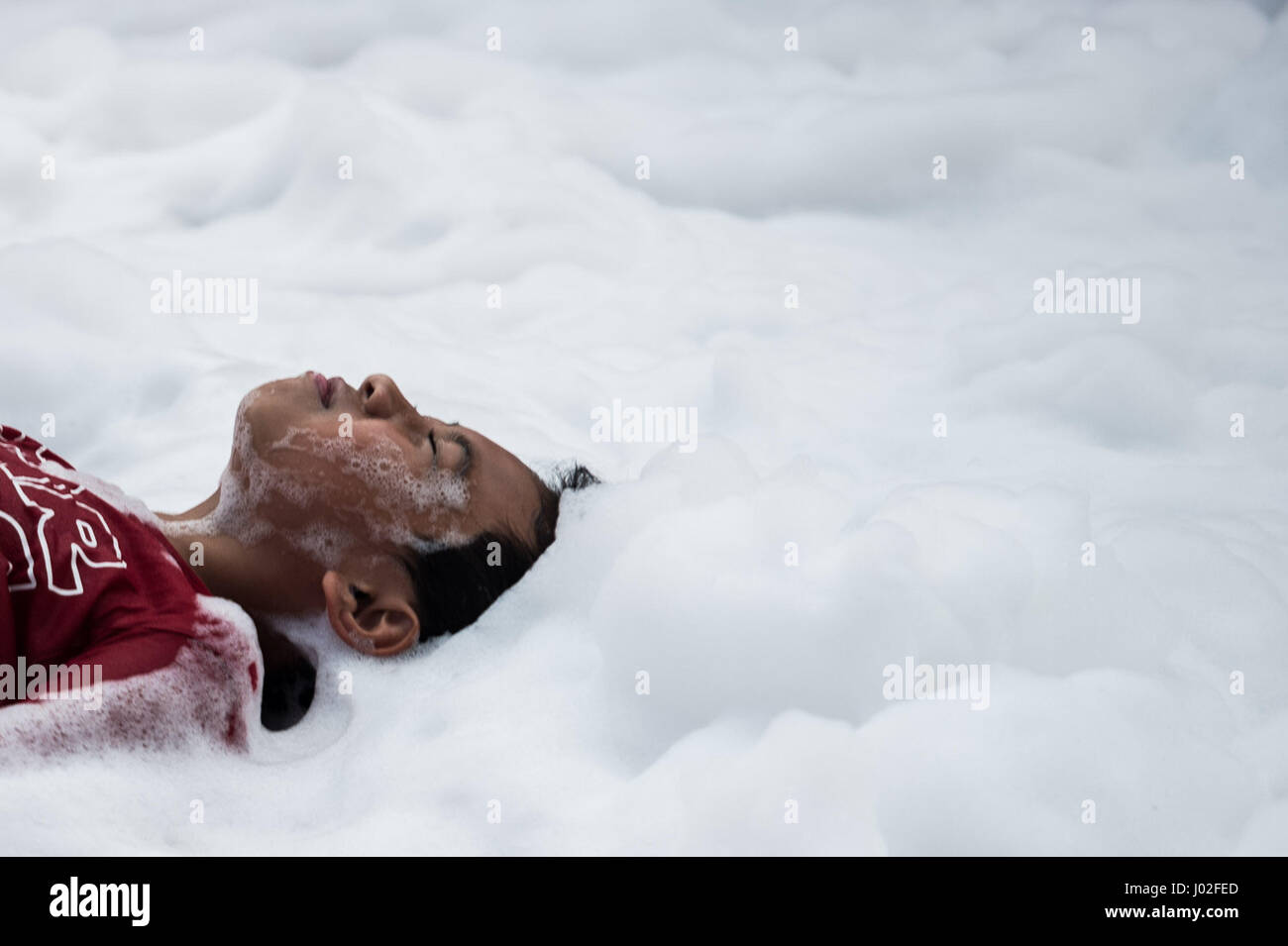 Jakarta, Indonesia. 9th Apr, 2017. A child lies in the soap foam after ...